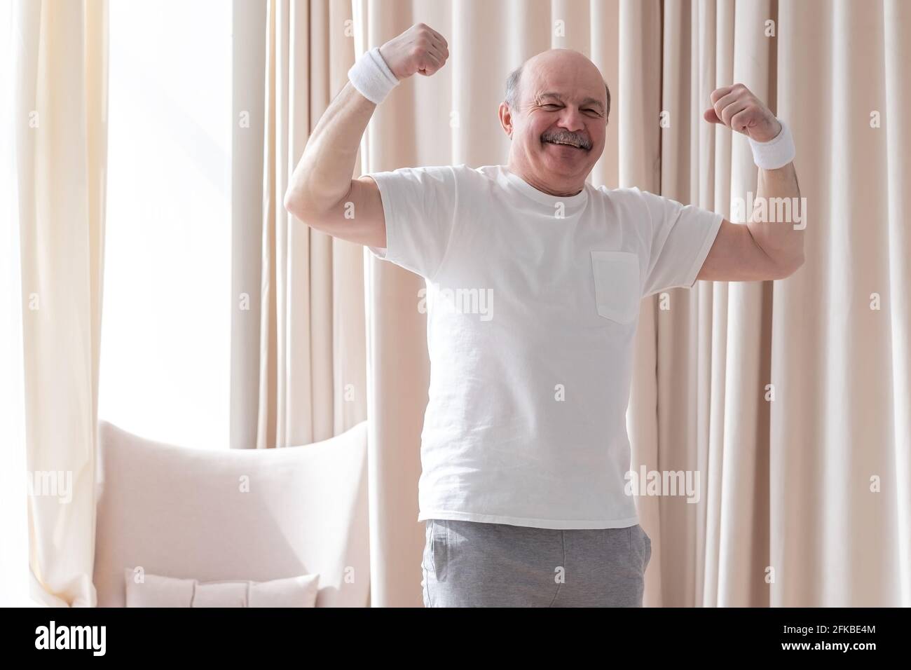 Senior man showing muscle being proud with his health Stock Photo - Alamy