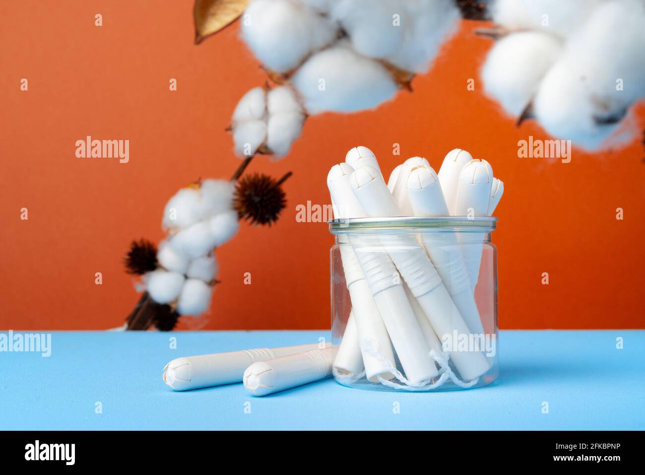 Female medical tampons and cotton flower on blue paper background Stock ...
