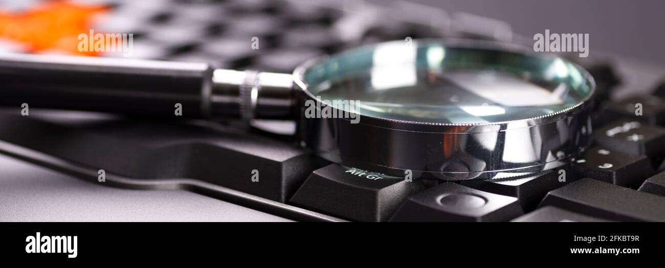 Magnifying glass on the keys of a black computer keyboard Stock Photo ...