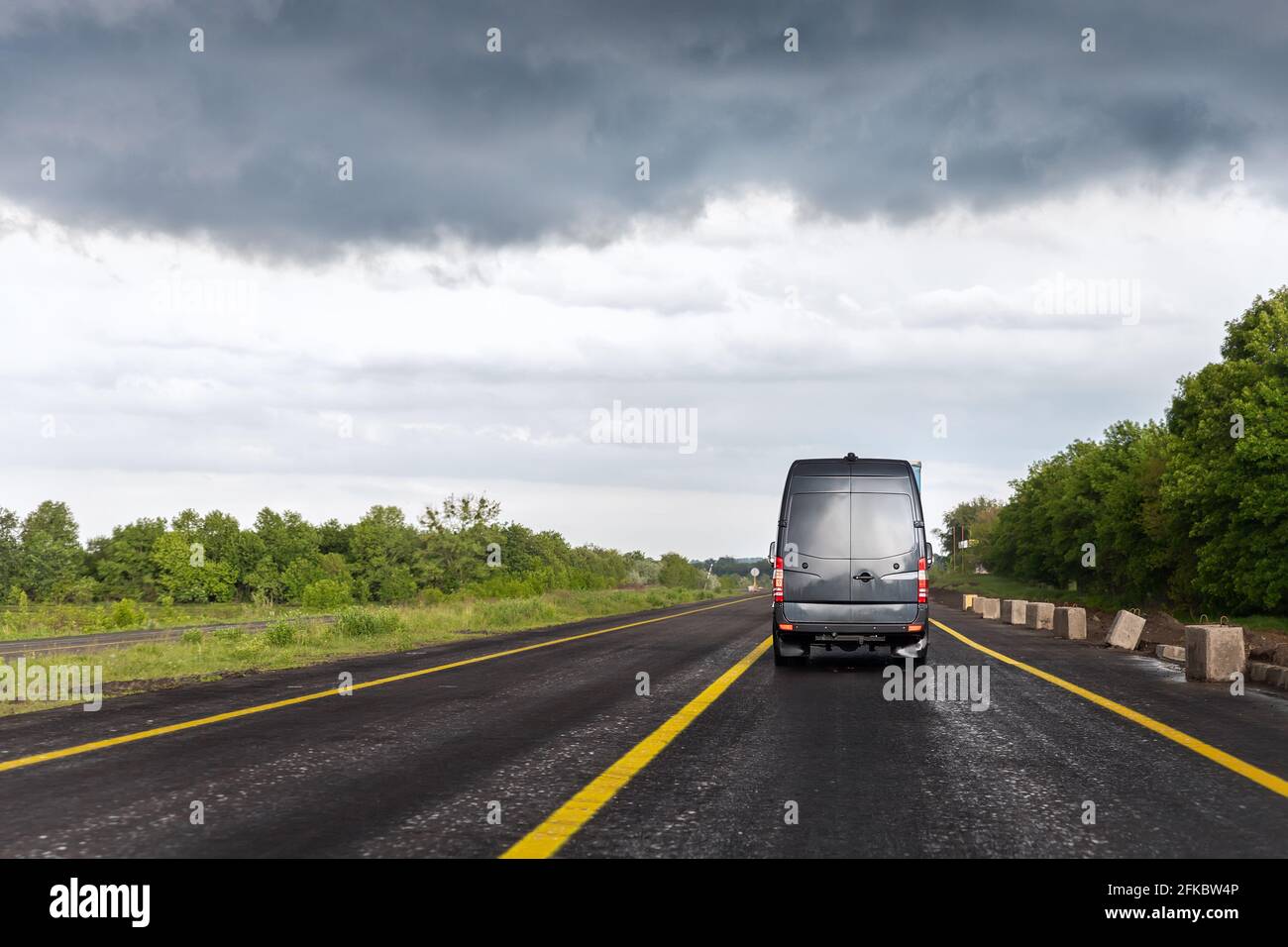 Back of delivery small shipment cargo courier van moving fast on wet ...