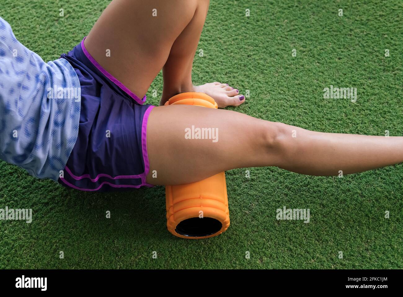 detail of the leg of a sportswoman in the gym relaxing and massaging ...