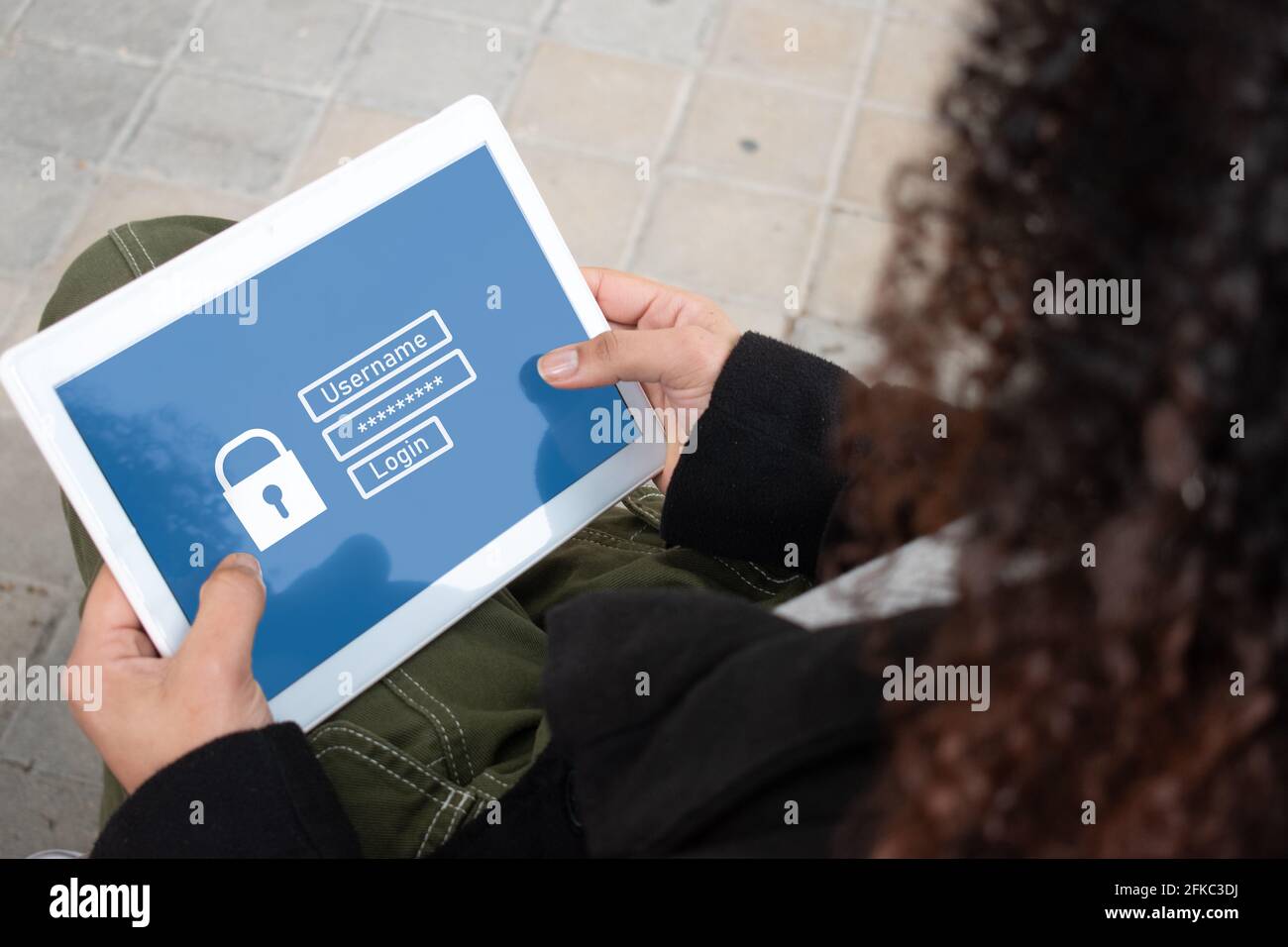 Close up of a girl using a tablet an enter her user and password ...