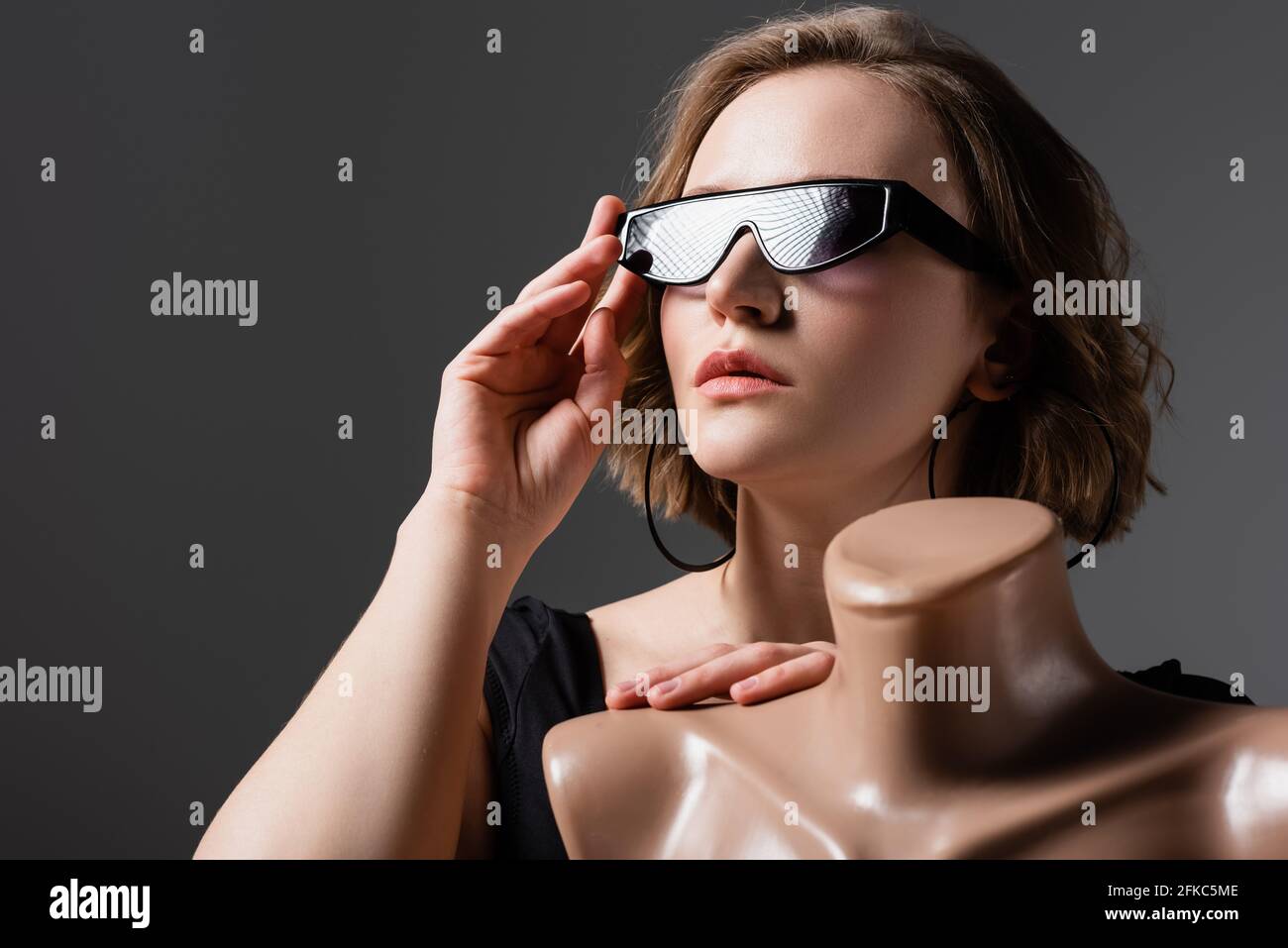 overweight young woman adjusting sunglasses and posing with plastic ...