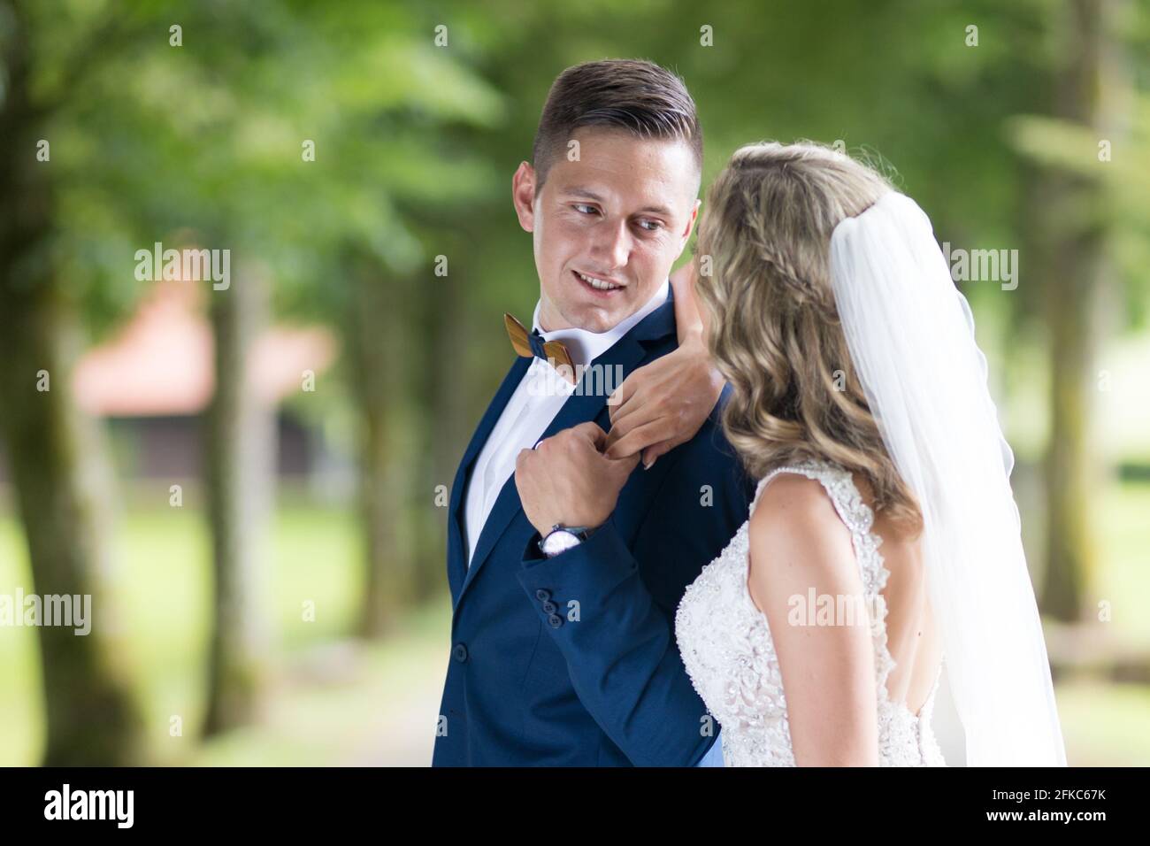 Bride and groom hugging tenderly posing during photo shooting in park ...