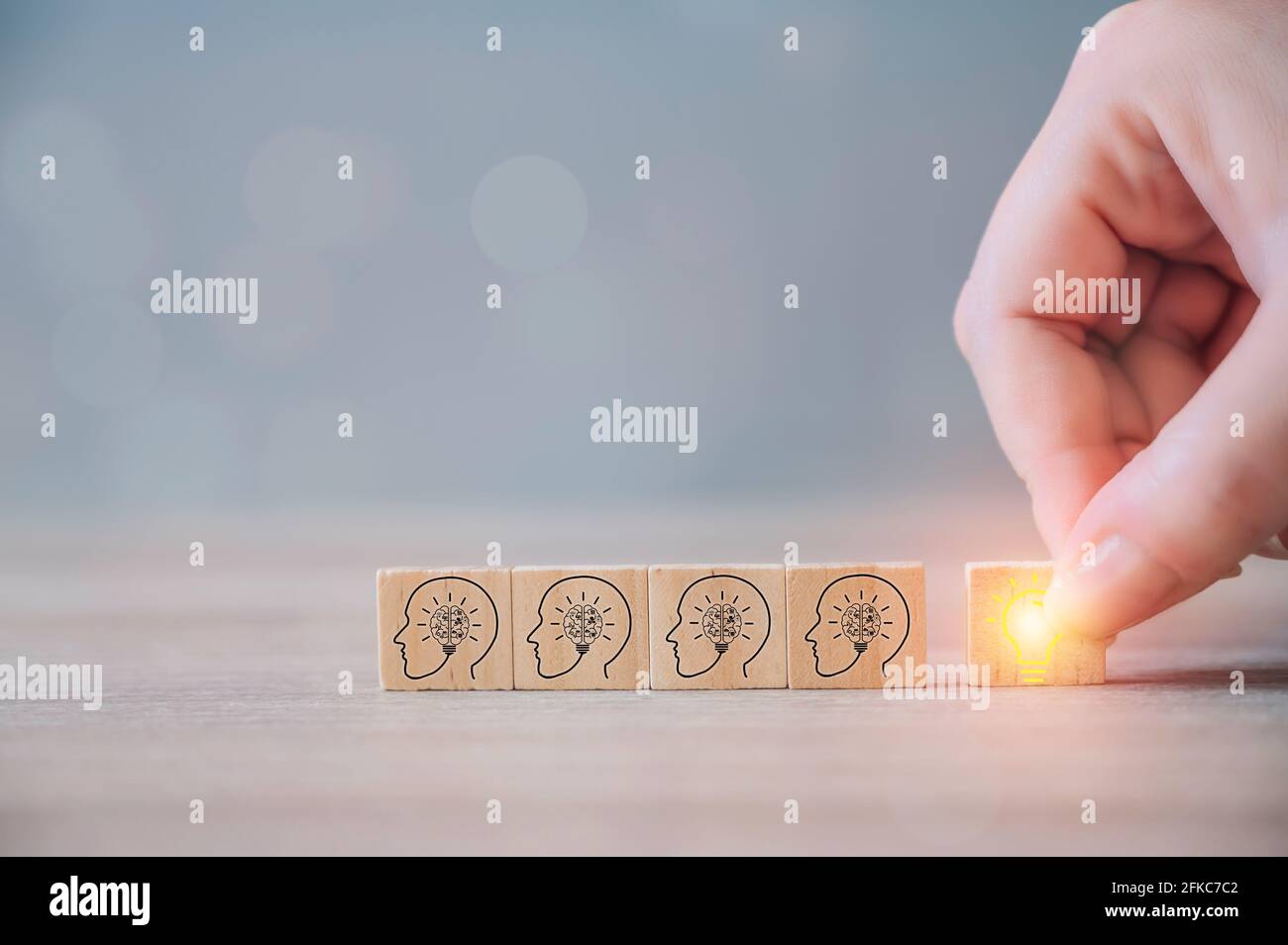 Creative new business idea and innovation concept. Hand choosing wooden cube block with light ...