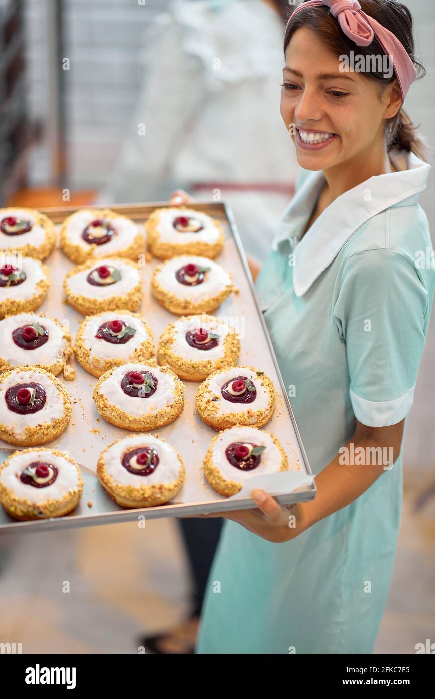 A beautiful retro looking young girl holding a tray with delicious ...