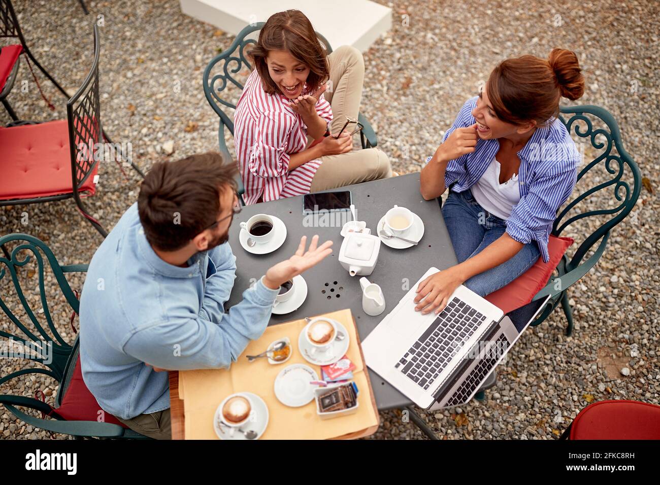 Three happy friends having coffee together at cafe Stock Photo - Alamy