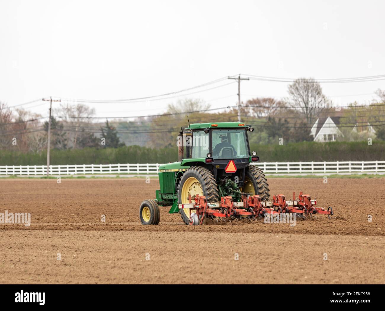 A John Deere farm tractor plowing field in Bridgehampton, NY Stock ...