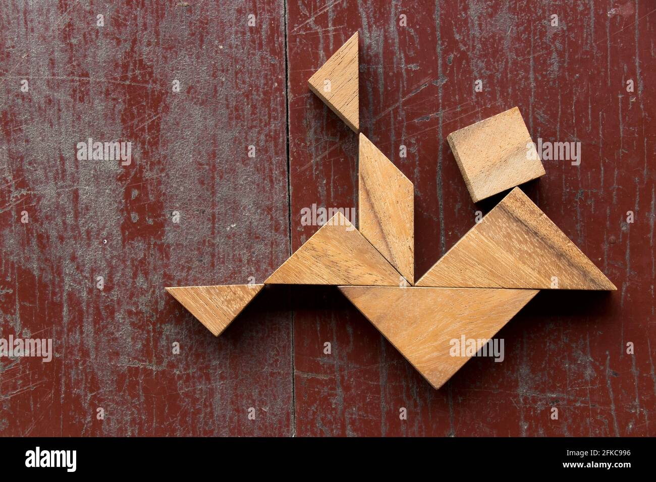 Tangram puzzle in falling man shape on red old wood background Stock ...