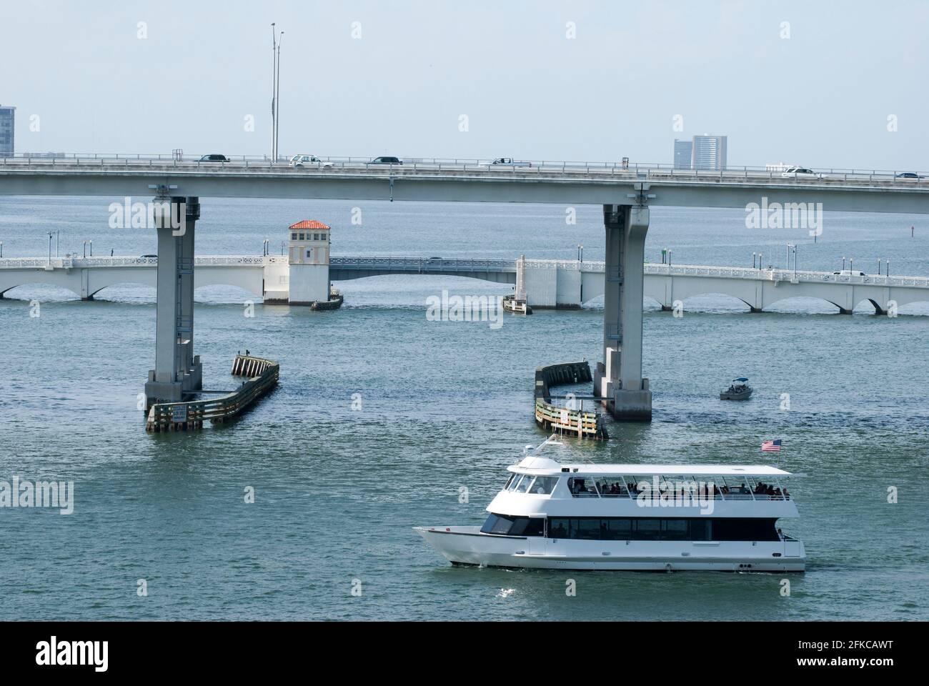 The ferry boat passing by near two bridges in Miami downtown harbor ...