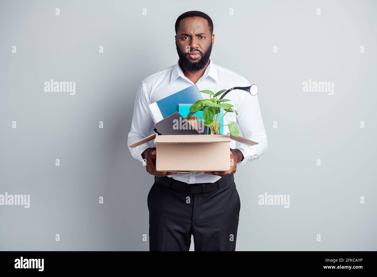 Photo portrait of sad worker keeping box with belongings fired from ...