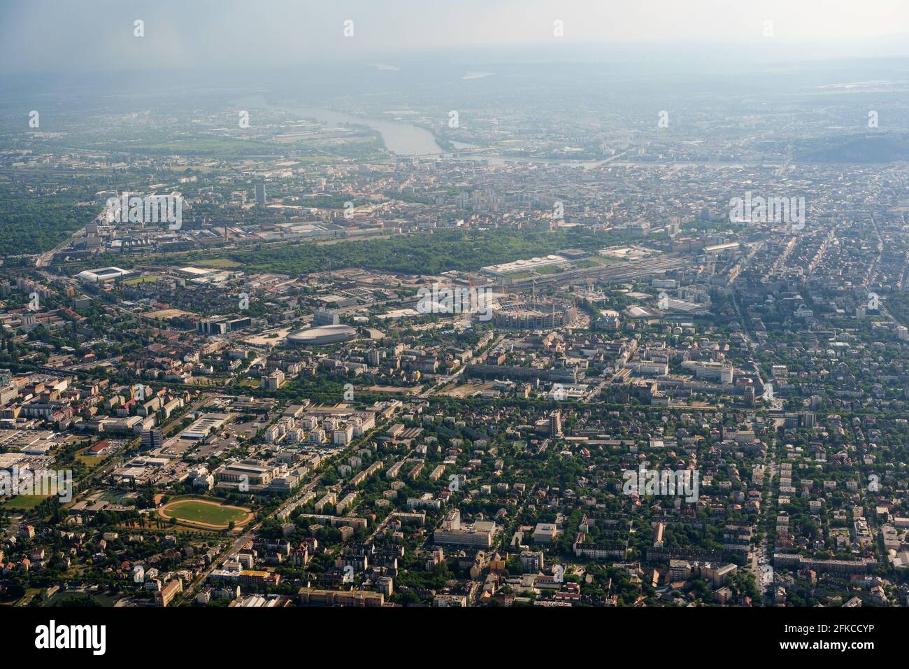 Airplane window view of modern houses surrounded by greenery in ...
