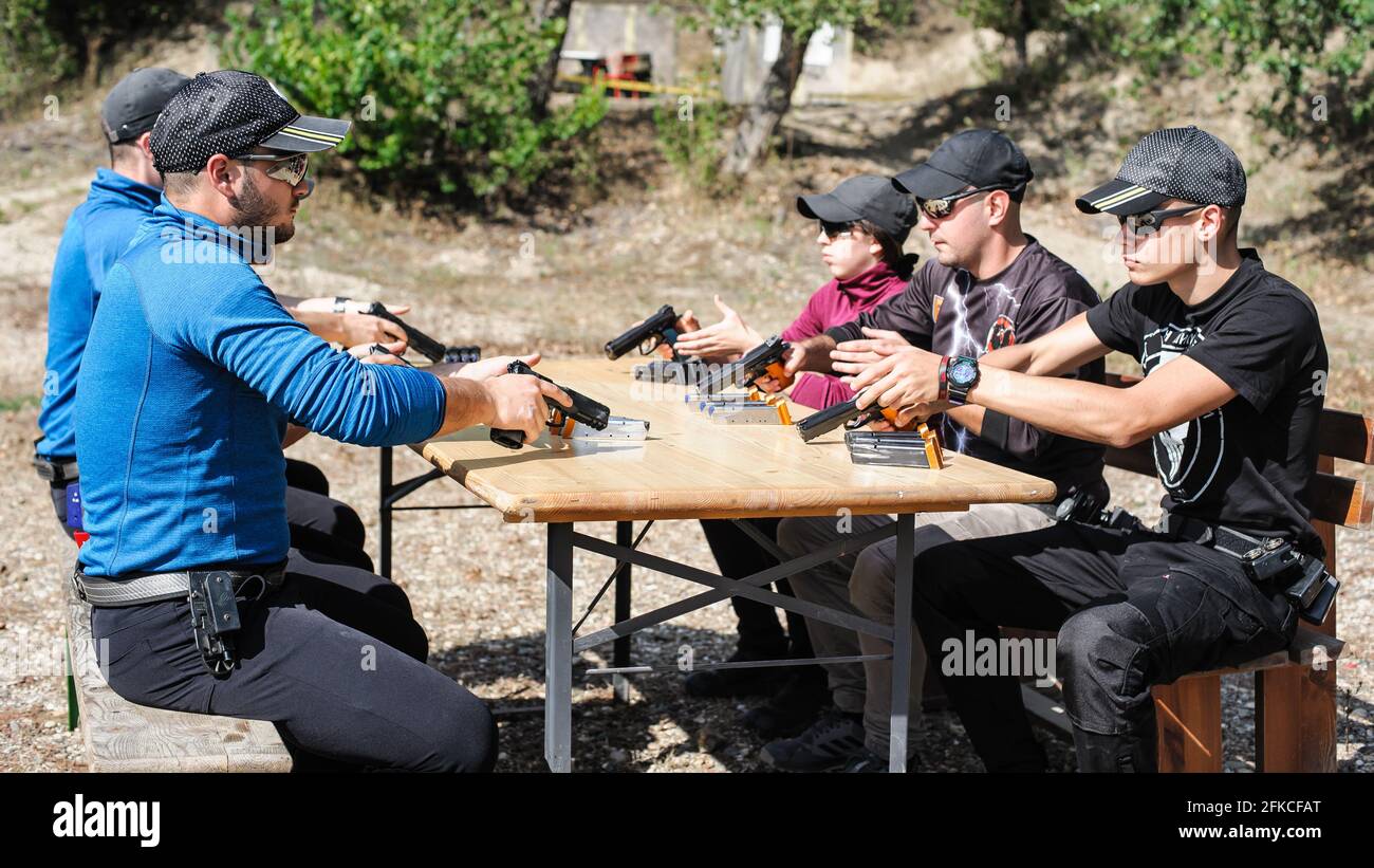 Group of students practice cartridge bullet clip gun reloading. Load ...