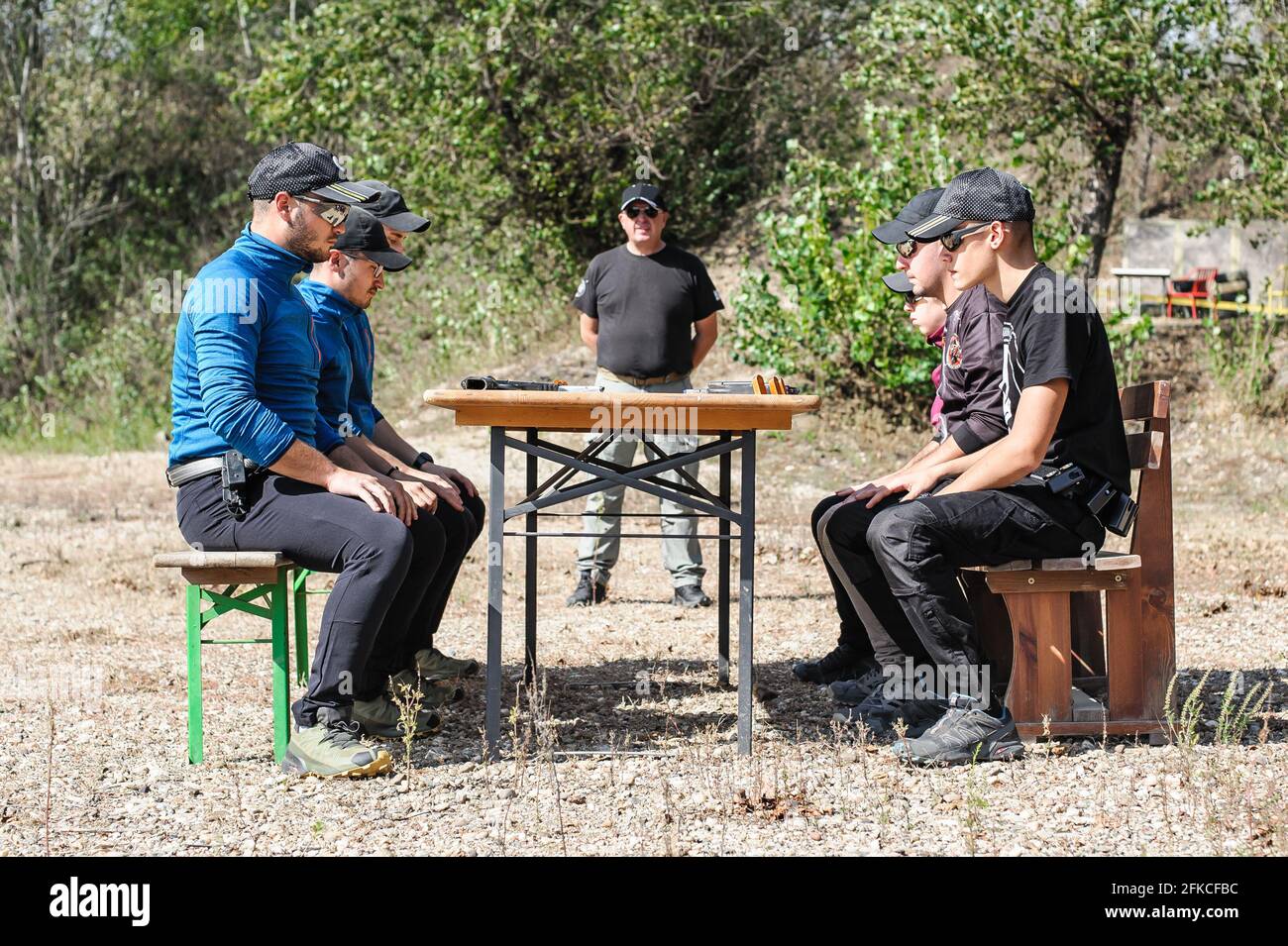 Group of students practice cartridge bullet clip gun reloading. Load ...