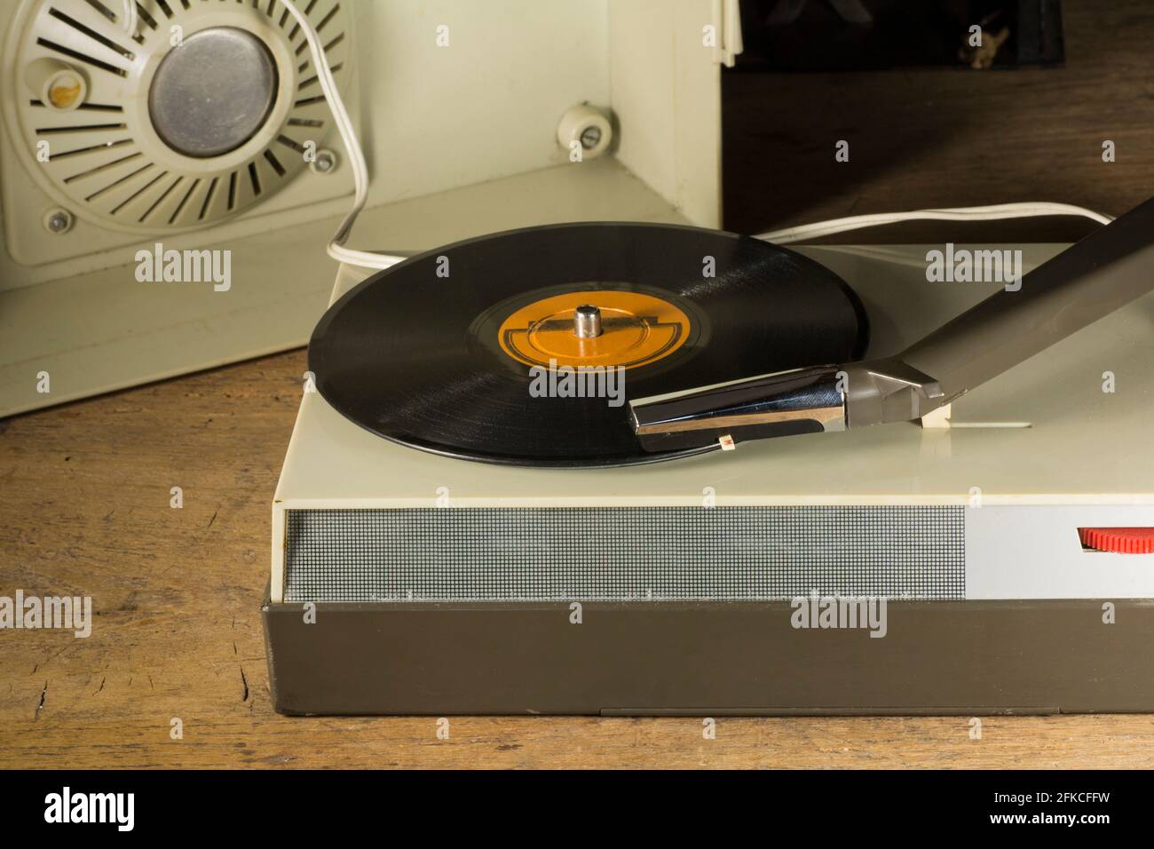 Old plastic record player playing a vinyl with a yellow label Stock ...