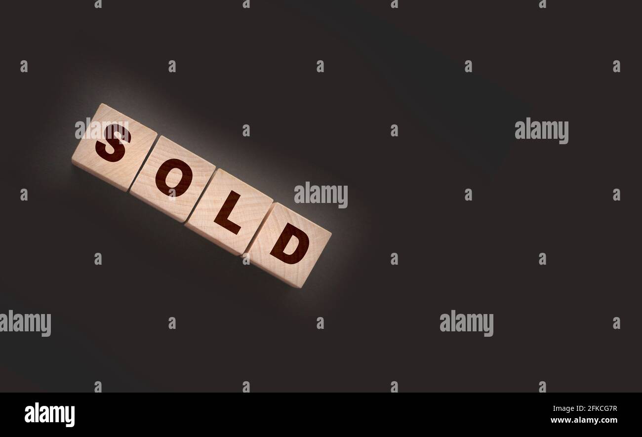 Sold Word Written In Wooden Cubes on black background. Real estate ...