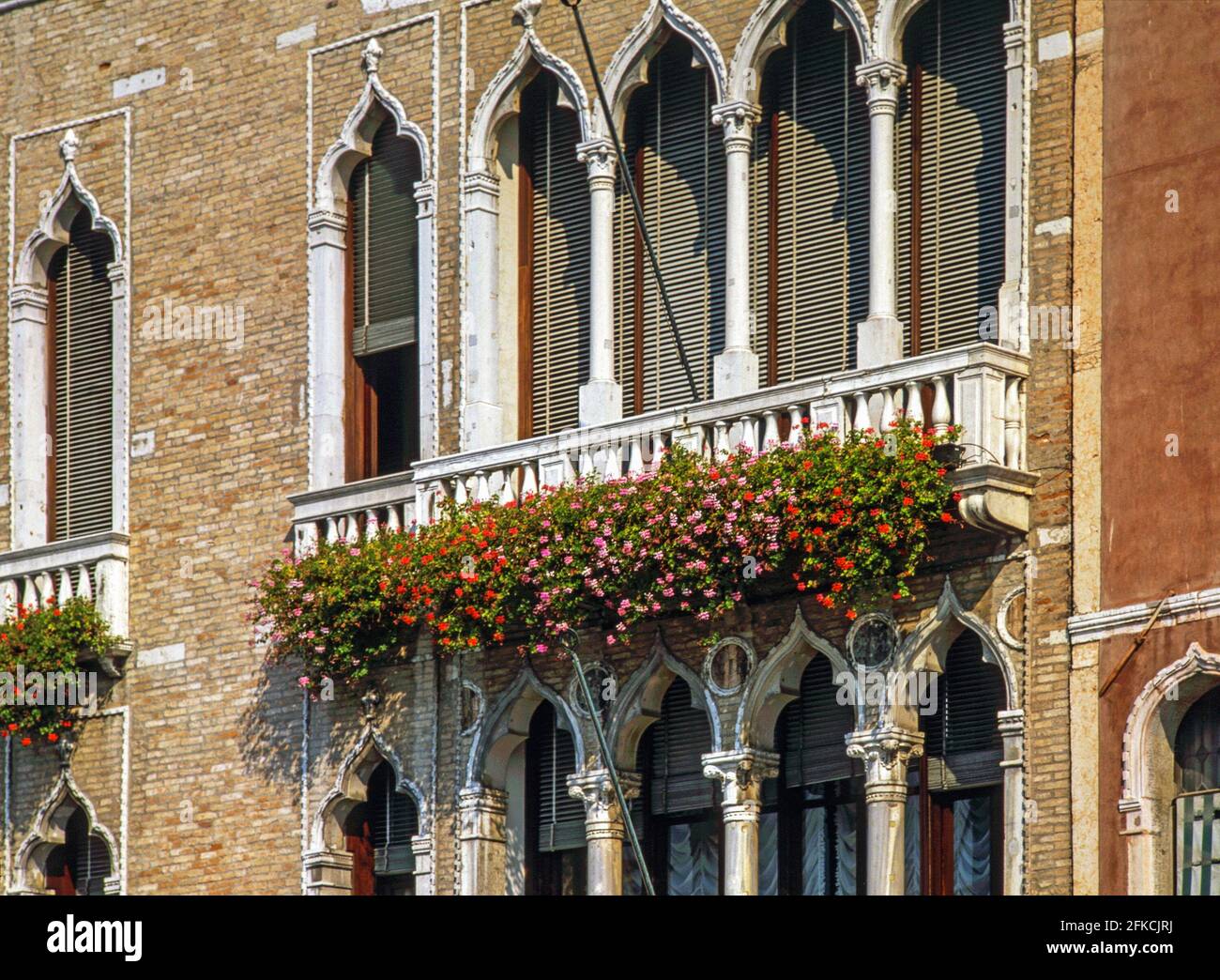 Windows with shades and balcony with flowers on Venice palace, Italy ...