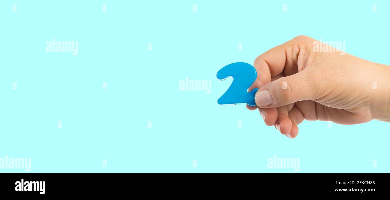 Woman's hand holding plastic number 2 symbol, close up image Stock ...