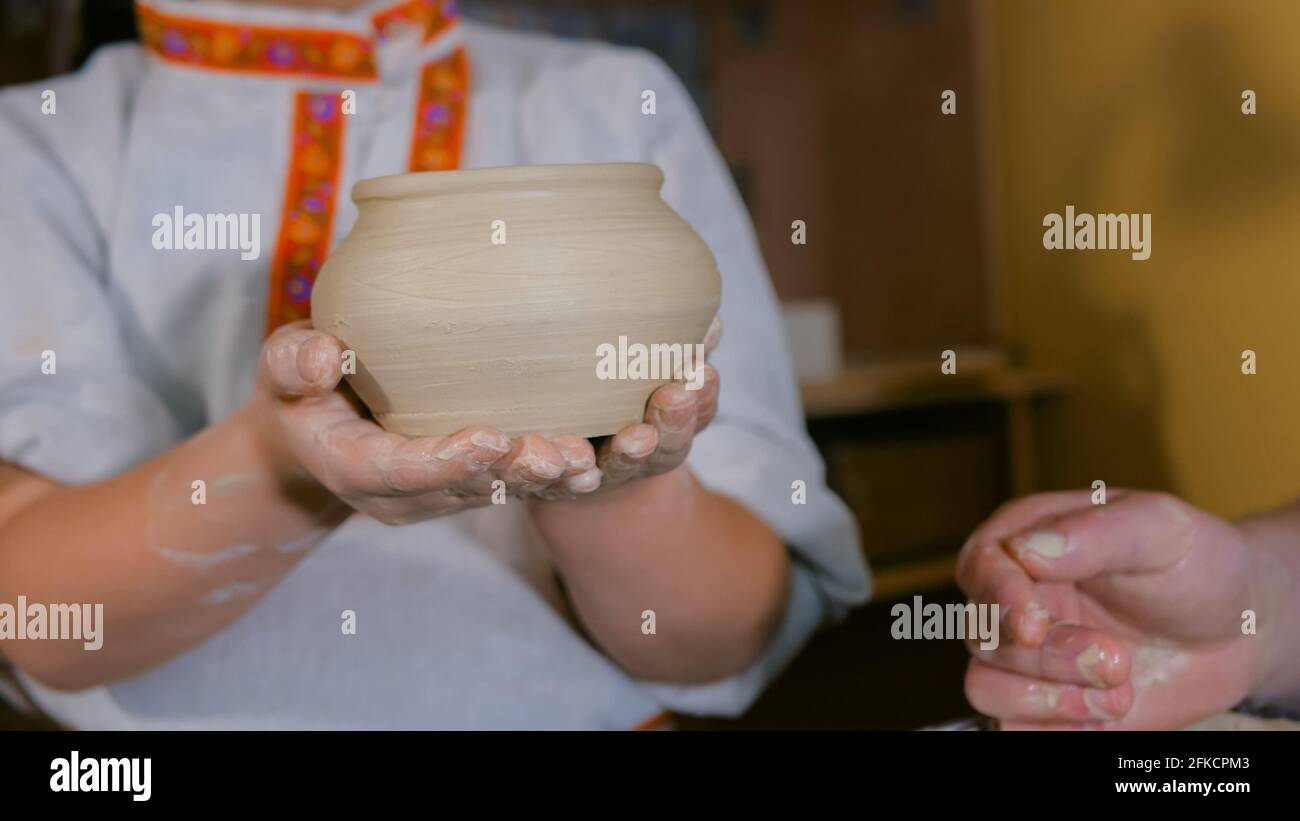 Teen boy holding ceramic pot in pottery studio Stock Photo - Alamy