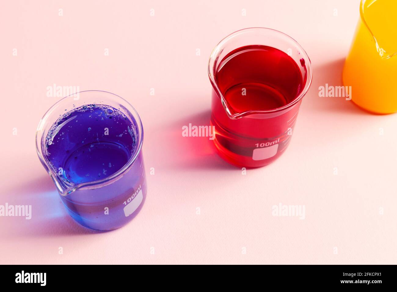 a glass vessel for a chemical laboratory with a blue and red liquid ...