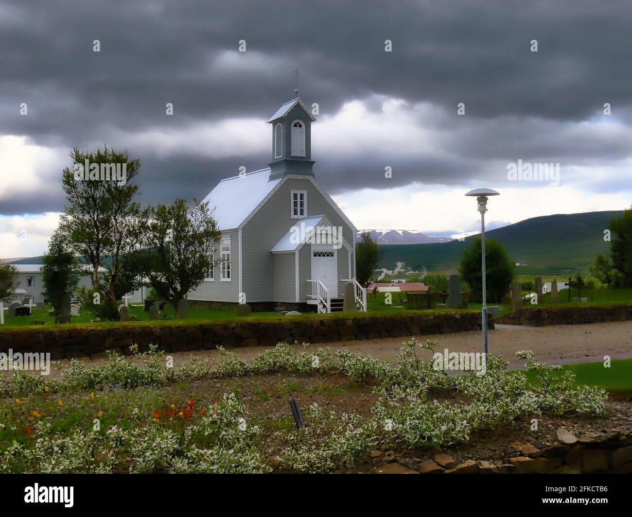 ICELAND, REYKHOLT - 04 JULY 2009: Reykholtskirkja under a dramatically ...