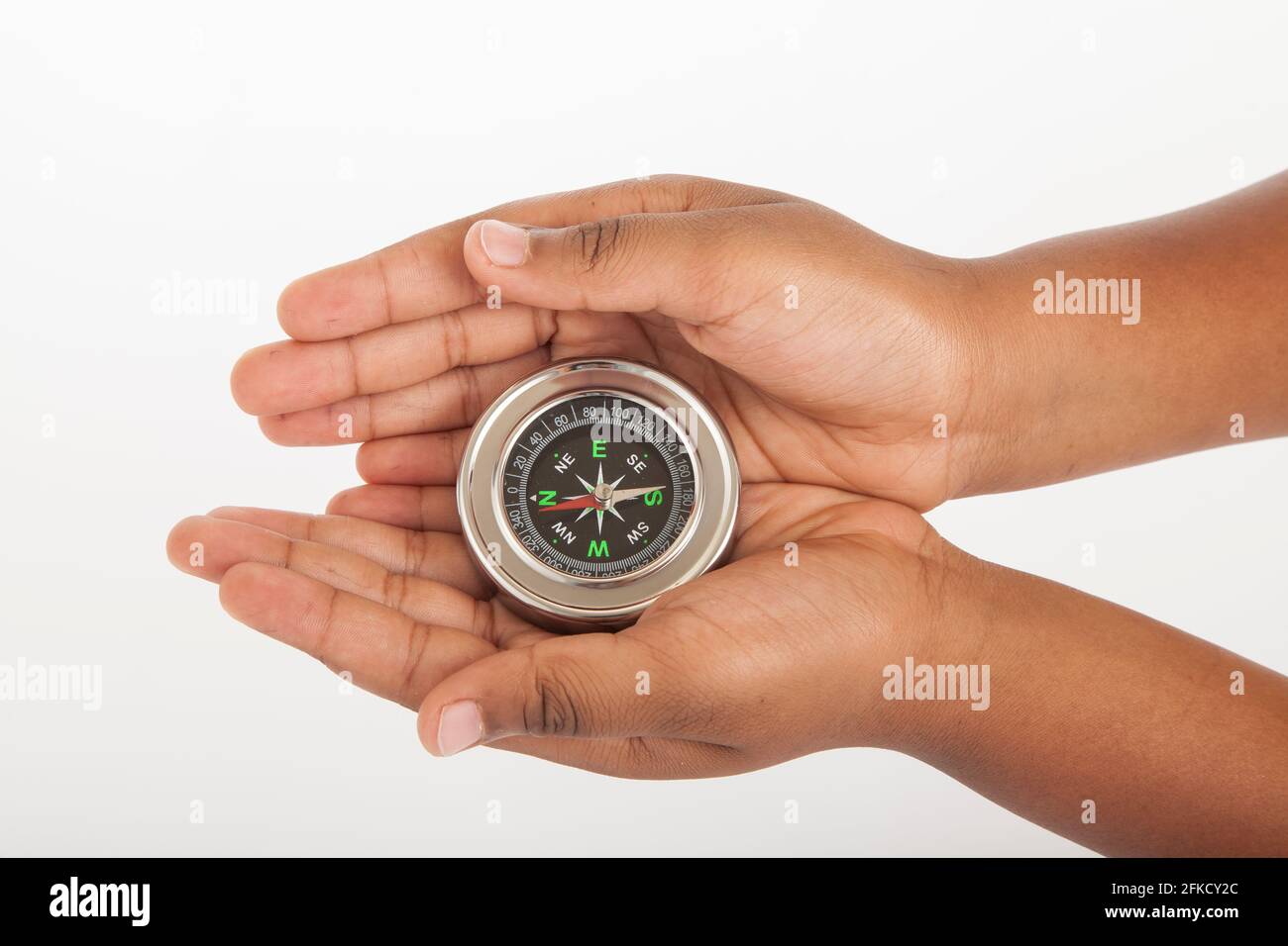 Child hands holding a compass on white background Stock Photo - Alamy