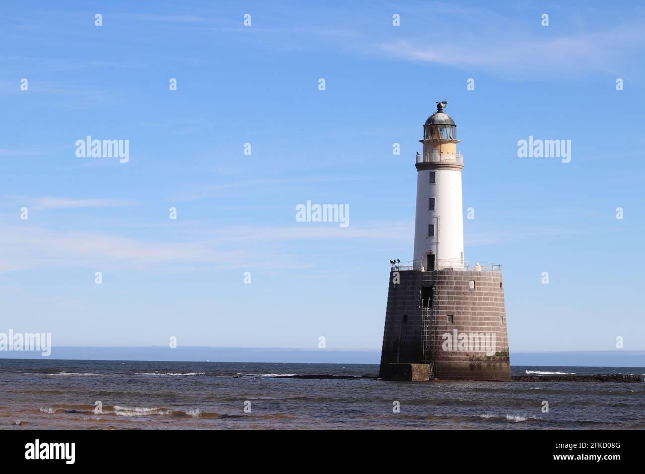 White lighthouse on pedestal in sea Stock Photo - Alamy