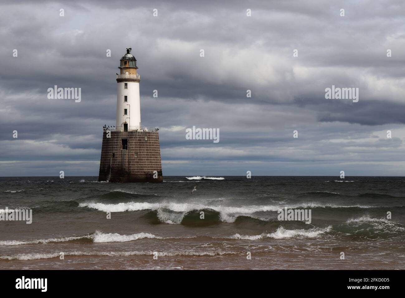 White lighthouse on pedestal in sea Stock Photo - Alamy