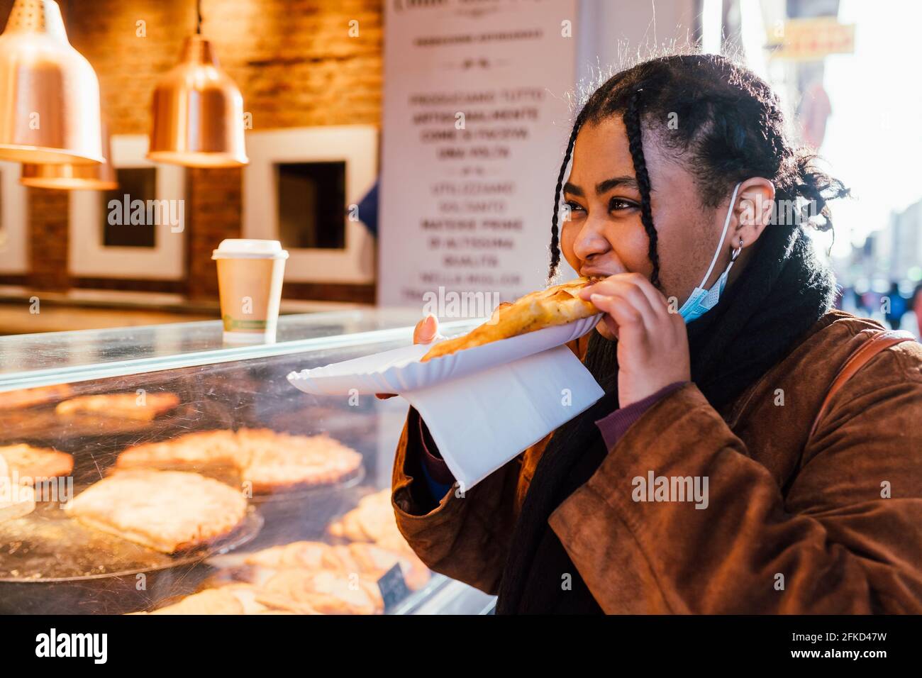 Woman eating snack at street food stand Stock Photo - Alamy