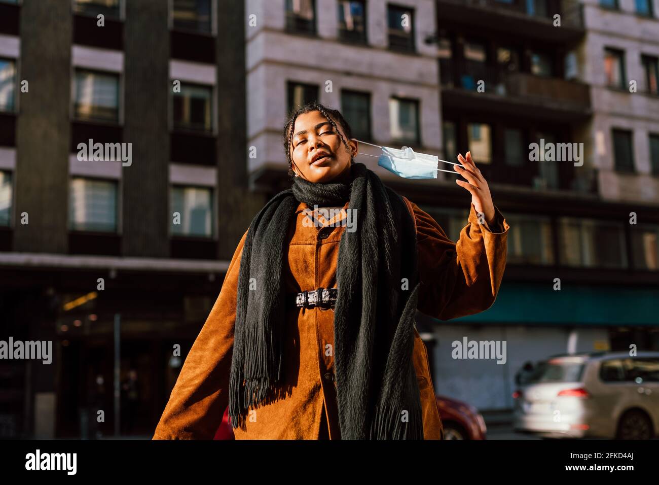 Young woman removing face mask outdoors Stock Photo - Alamy