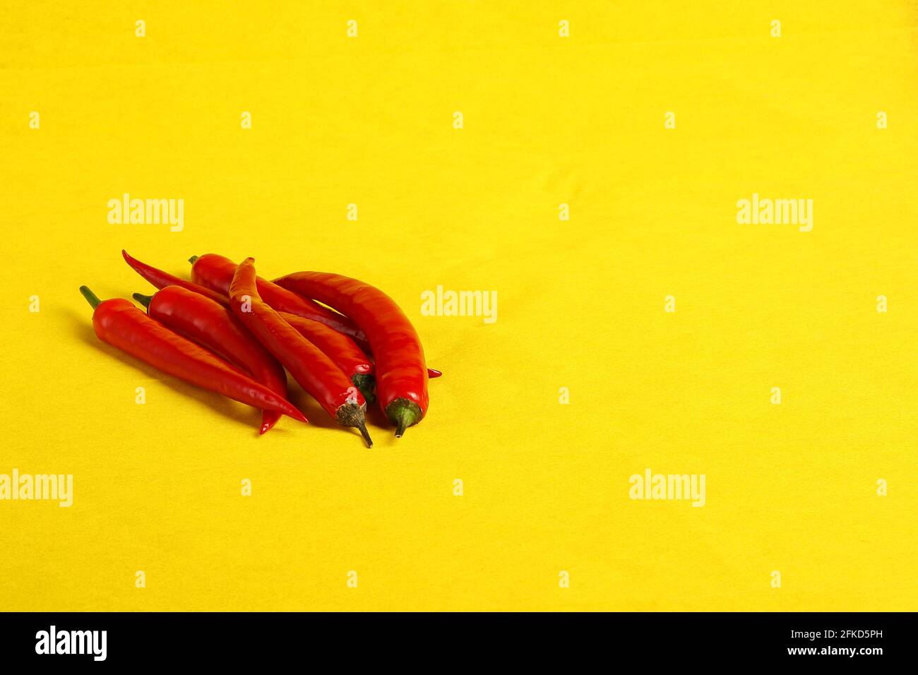 Red pepper pod on a yellow background close-up Stock Photo - Alamy