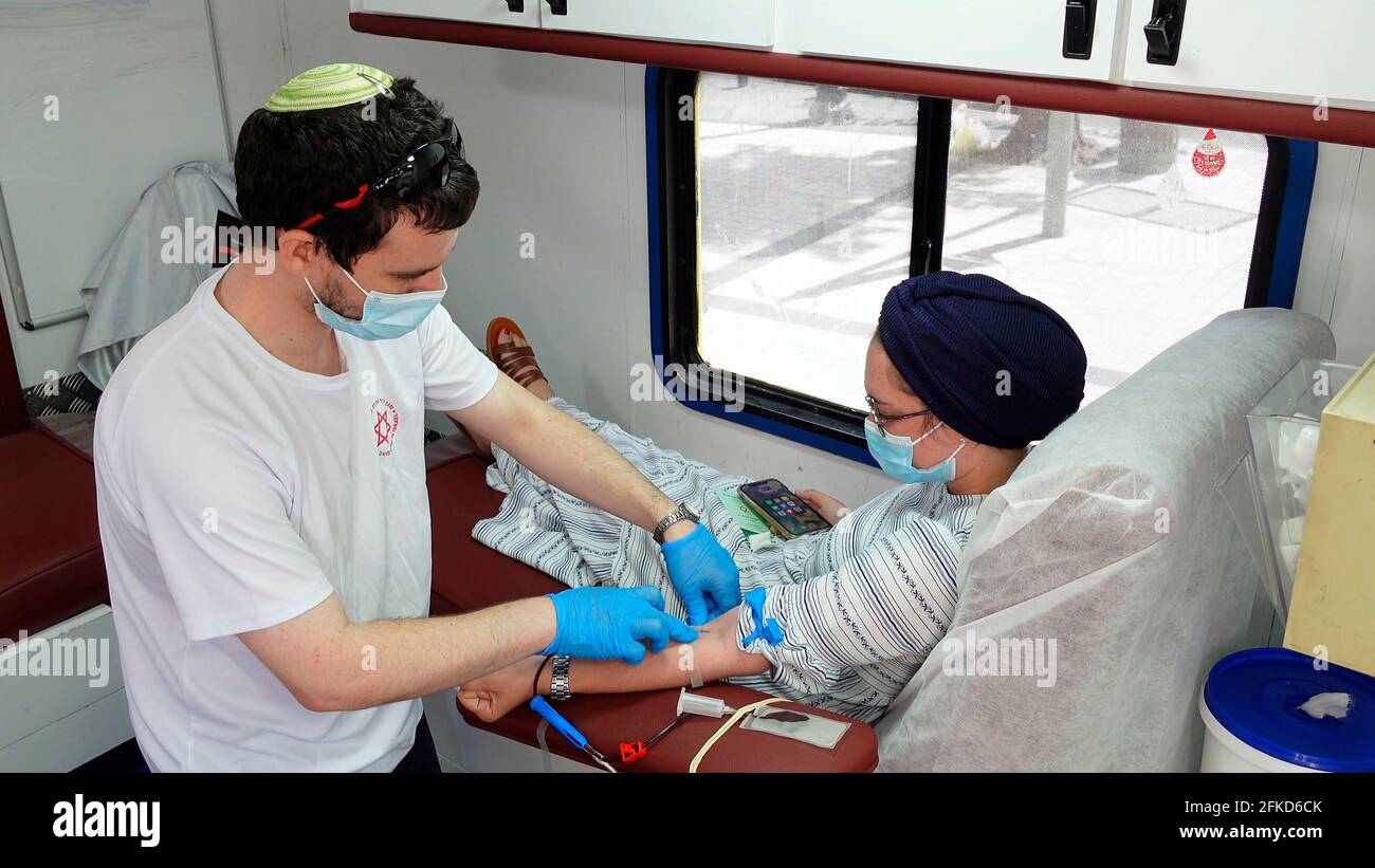 An Israeli religious woman donates blood inside blood donation vehicle ...