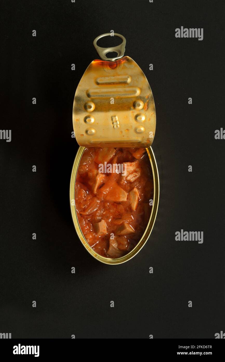 can of squid in American sauce on black background Stock Photo - Alamy
