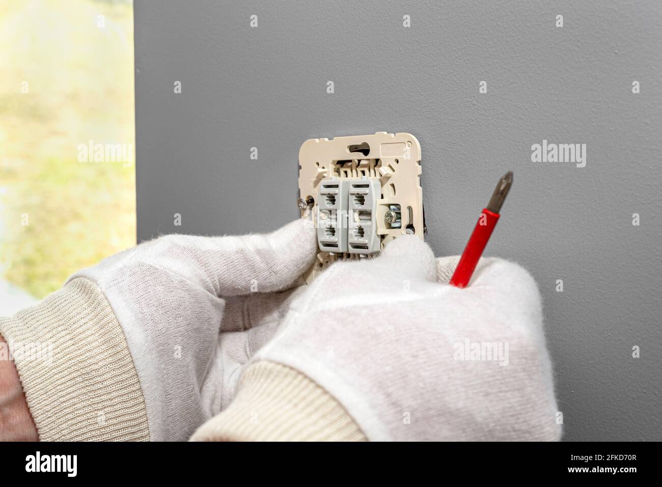 The electrician puts the roller shutter switch up and down in the ...