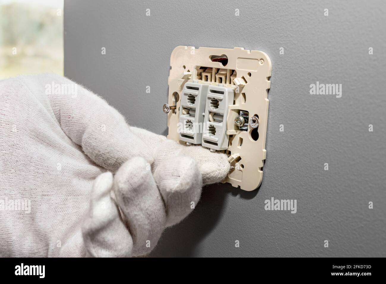 The electrician puts the roller shutter switch up and down in the ...