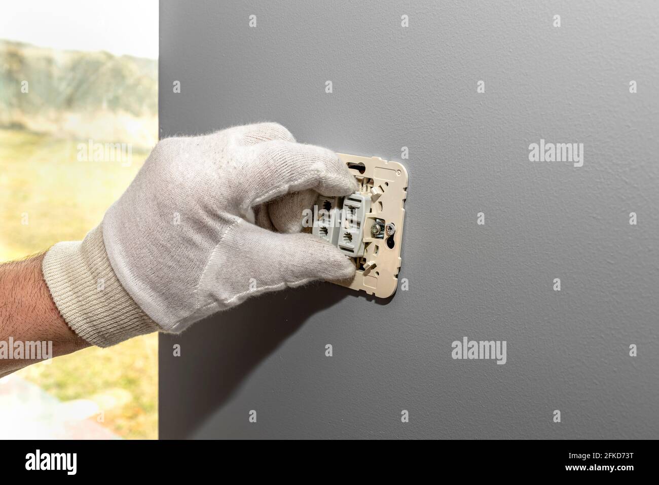 The electrician puts the roller shutter switch up and down in the ...