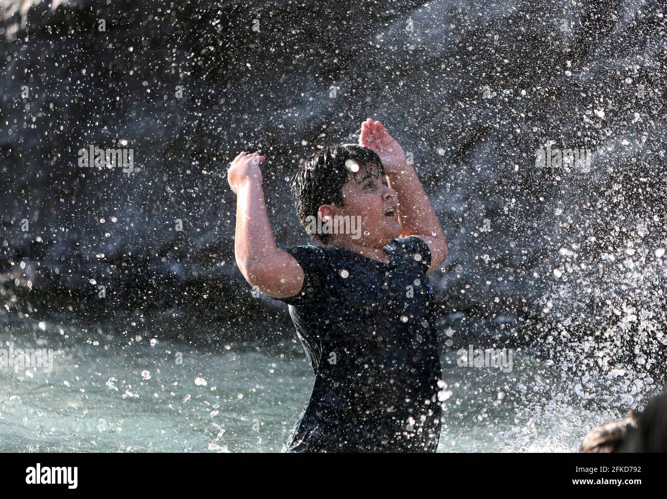 Shahr E Rey, Iran. 30th Apr, 2021. A boy cools himself in water during ...