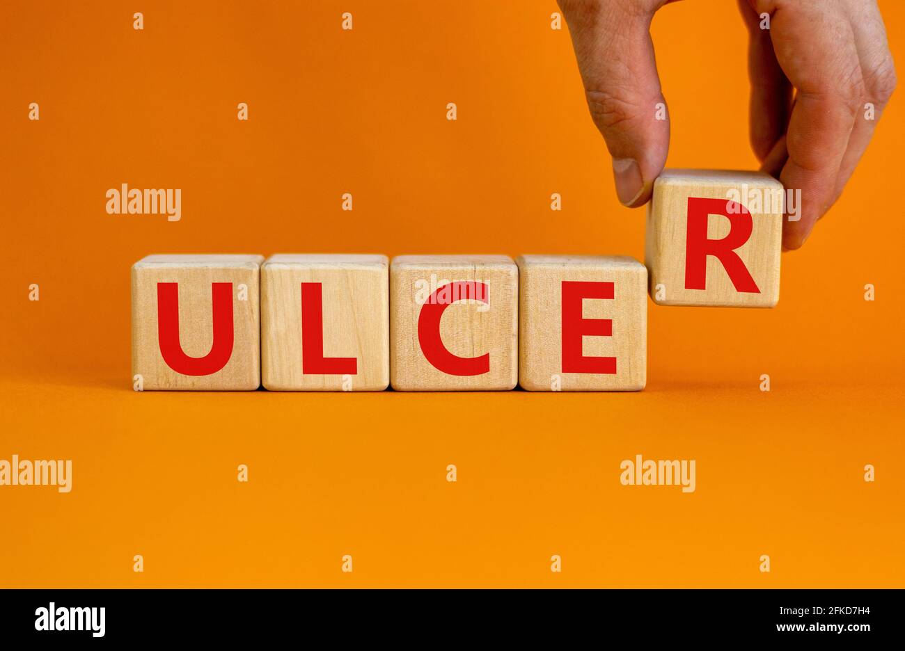 Stomach ulcer symbol. Wooden cubes with the word 'ulcer'. Doctor hand ...
