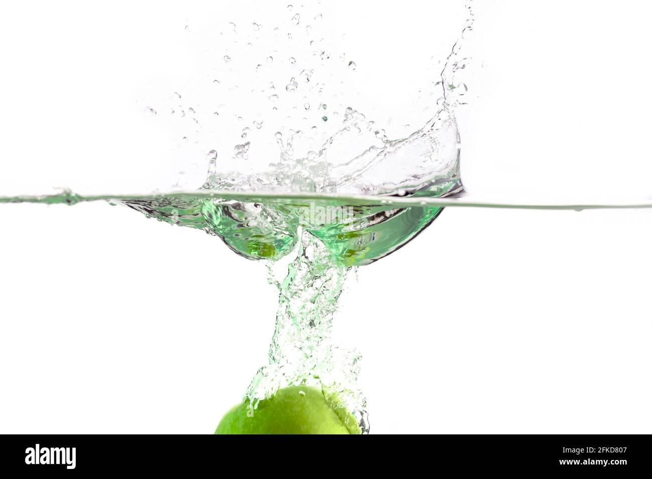 drop one green apple into the water with splashes on a white background ...