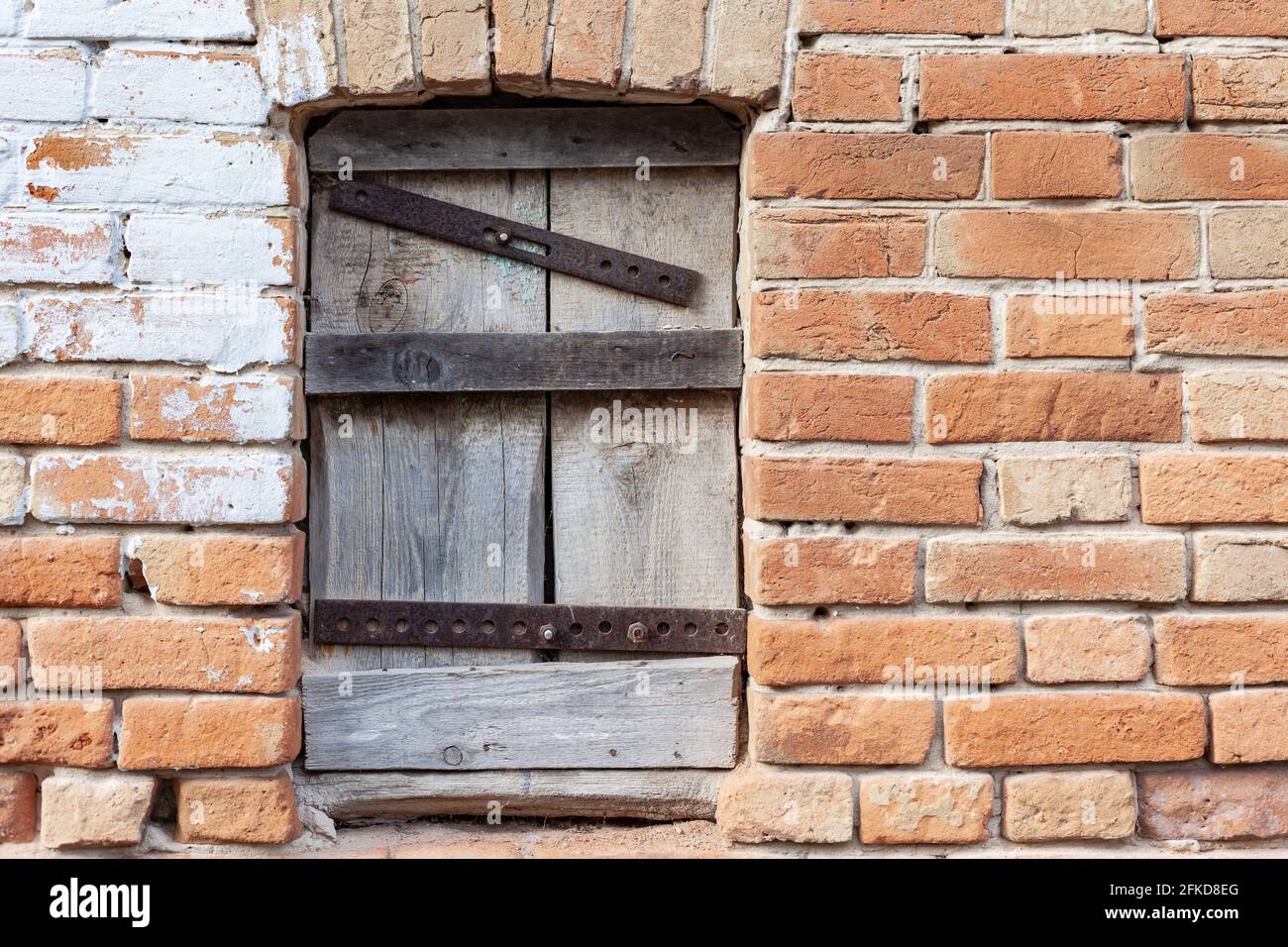 boarded-up window against the red brick wall, place under the text ...