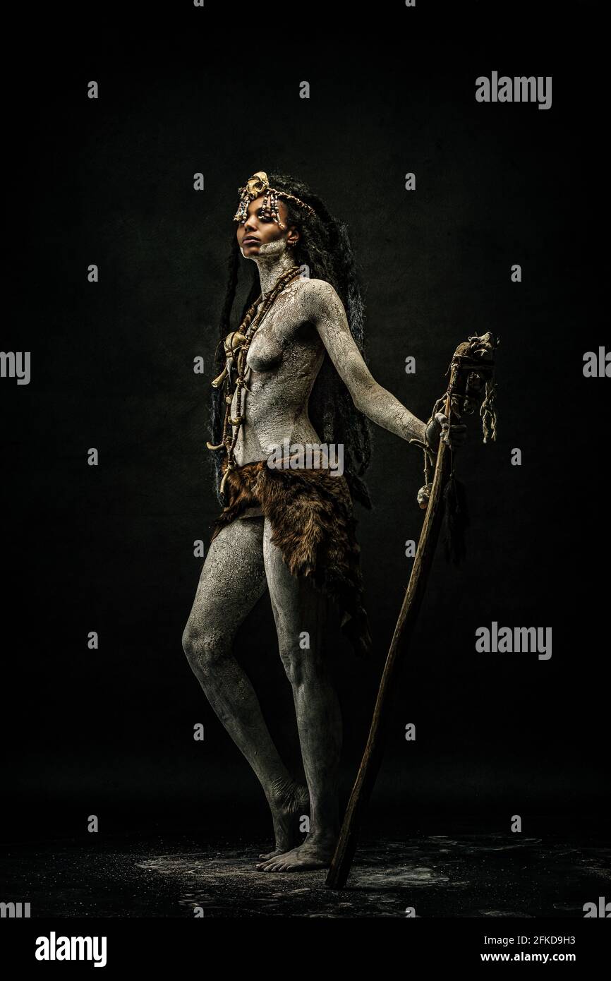Tribal shaman covered in clay, wearing dreadlocks, bone necklaces and a ...