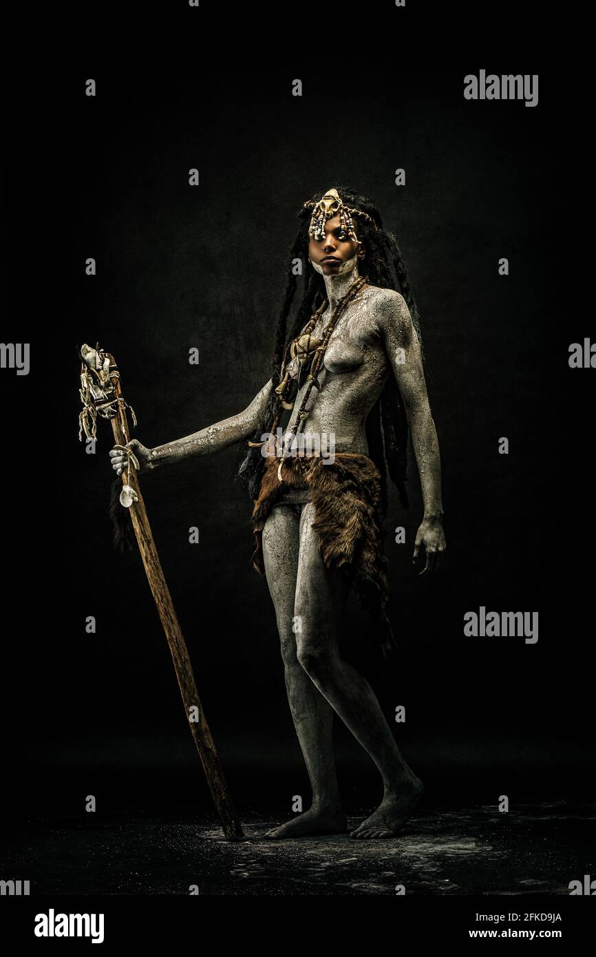 Tribal shaman covered in clay, wearing dreadlocks, bone necklaces and a ...