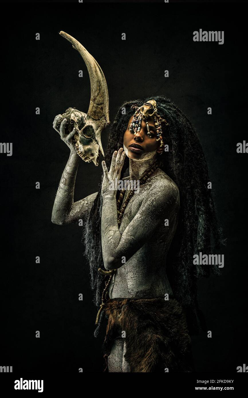 Portrait of a shaman covered in clay, wearing dreadlocks, bone ...