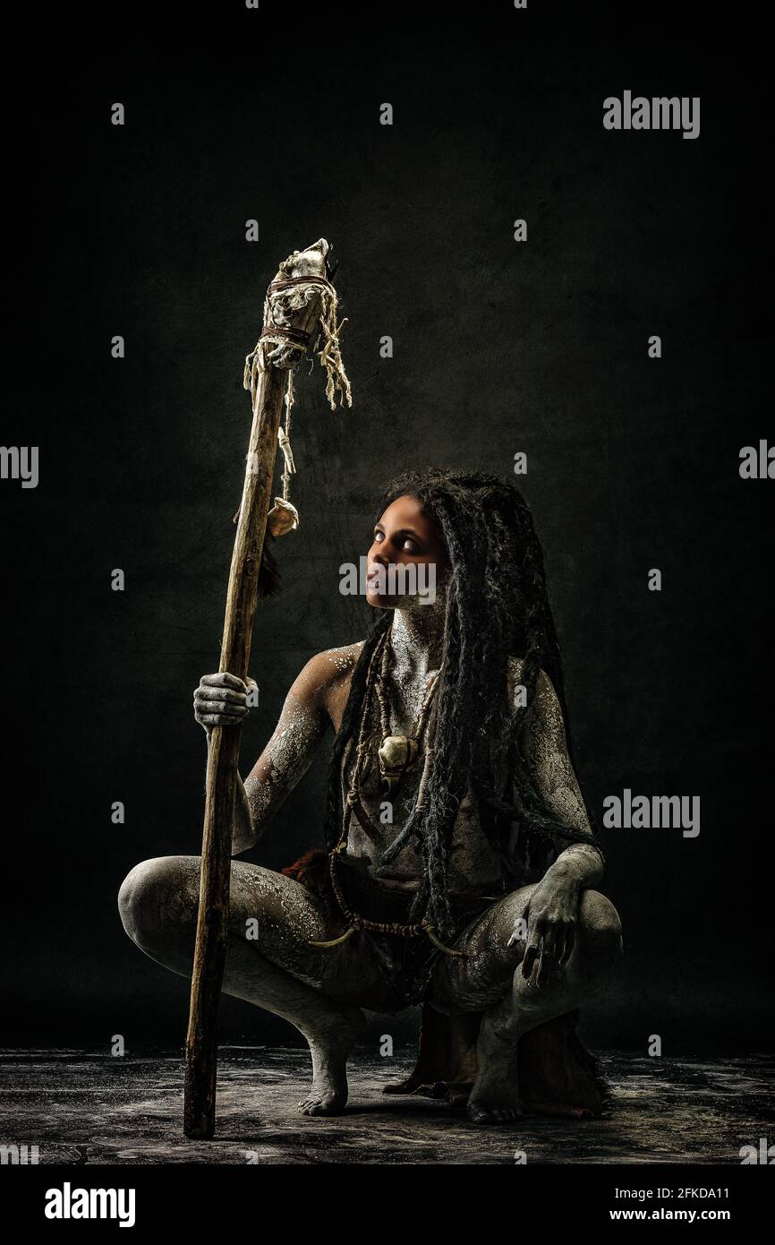 Tribal shaman covered in clay, wearing dreadlocks, bone necklaces and a ...