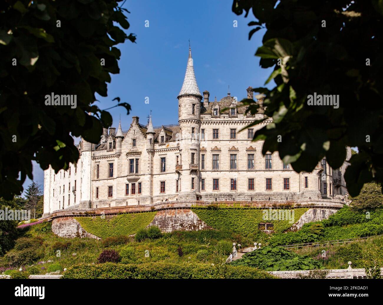 A castle with a clock tower in front of a building Stock Photo - Alamy