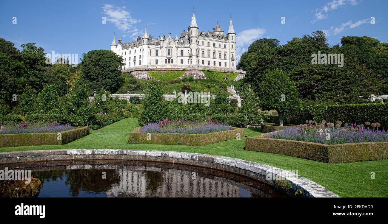 A castle with a clock tower in front of a building Stock Photo - Alamy