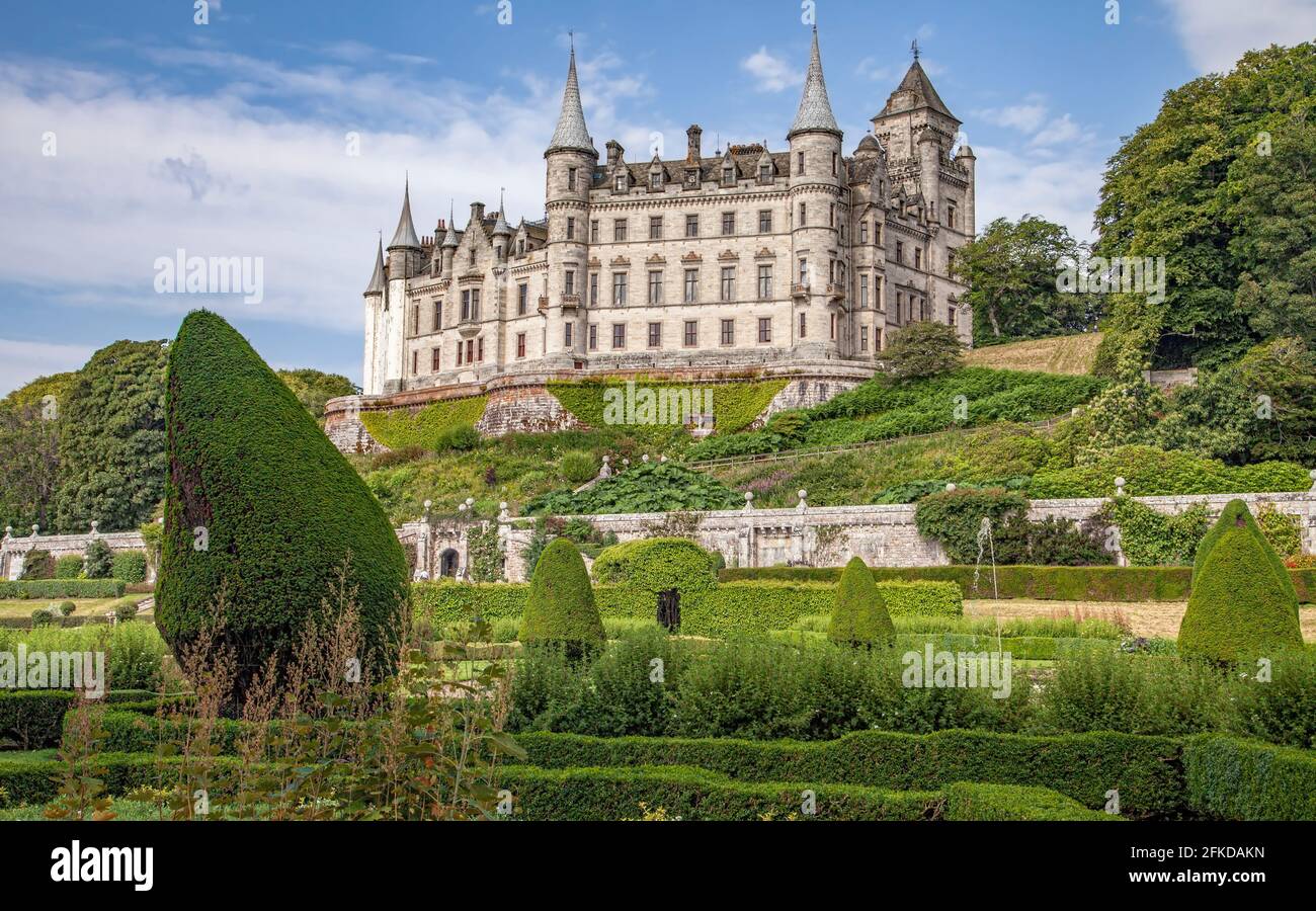 A castle with a clock tower in front of a building Stock Photo - Alamy