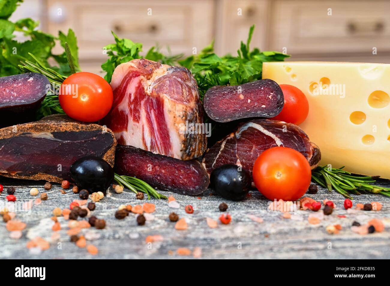 Close-up of assorted dry-cured meat on the wooden gray table with ...