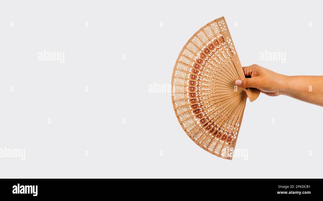 hand holding wooden folding fan - White background Stock Photo - Alamy