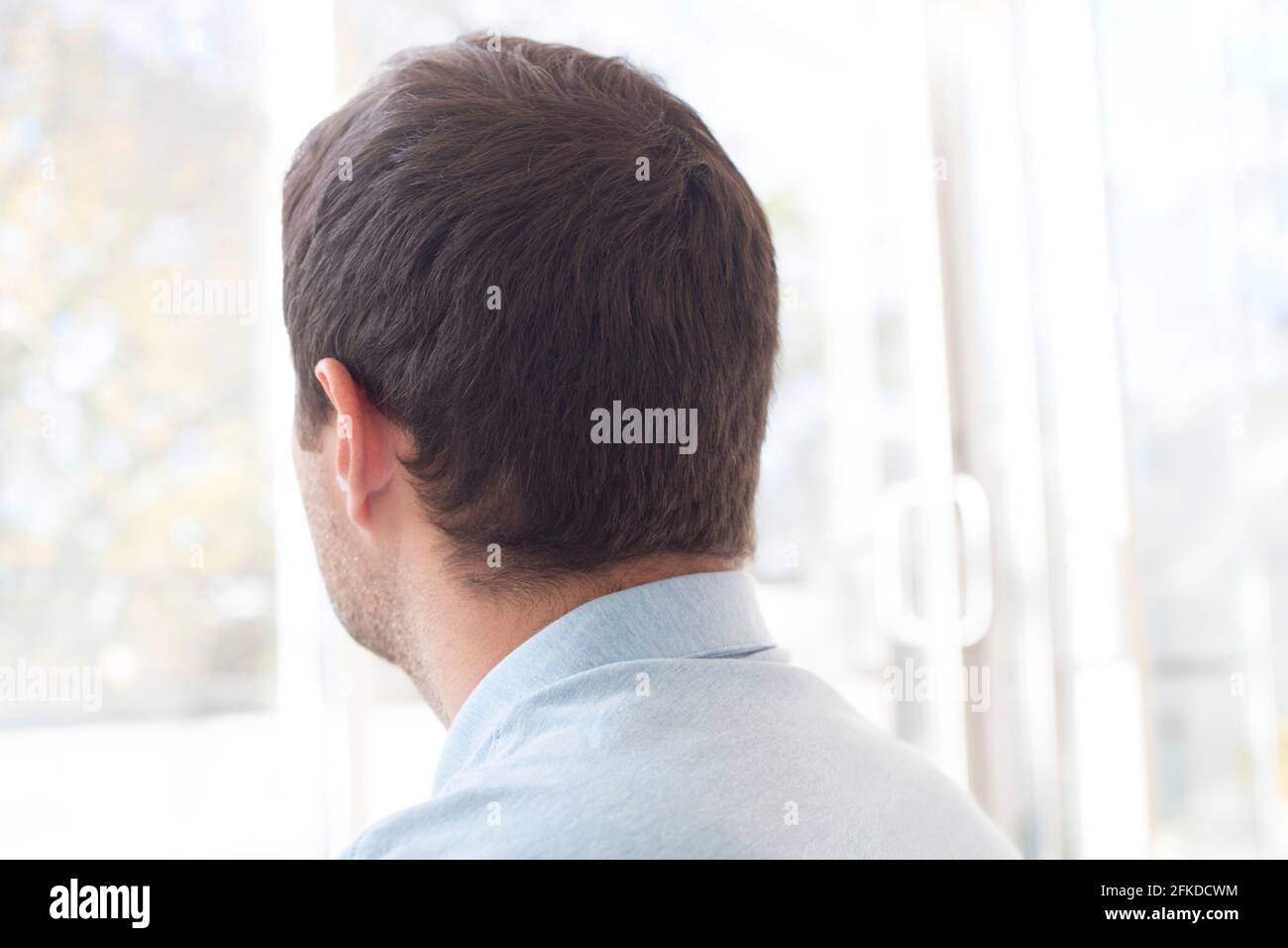 Man looking out of window Stock Photo - Alamy